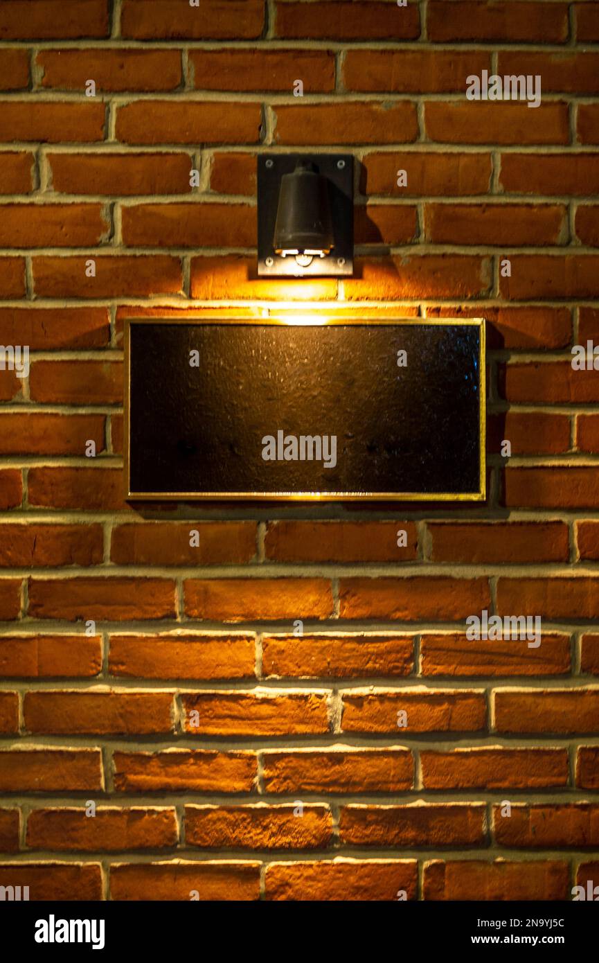 Plaque on a brick wall illuminated at night Stock Photo - Alamy