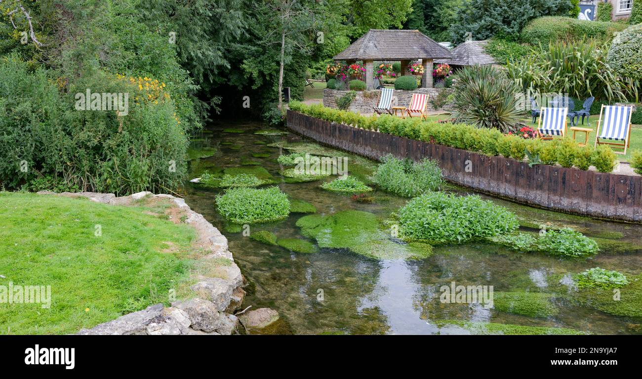 Riverside seating in gardens along the River Coln; Bibury ...