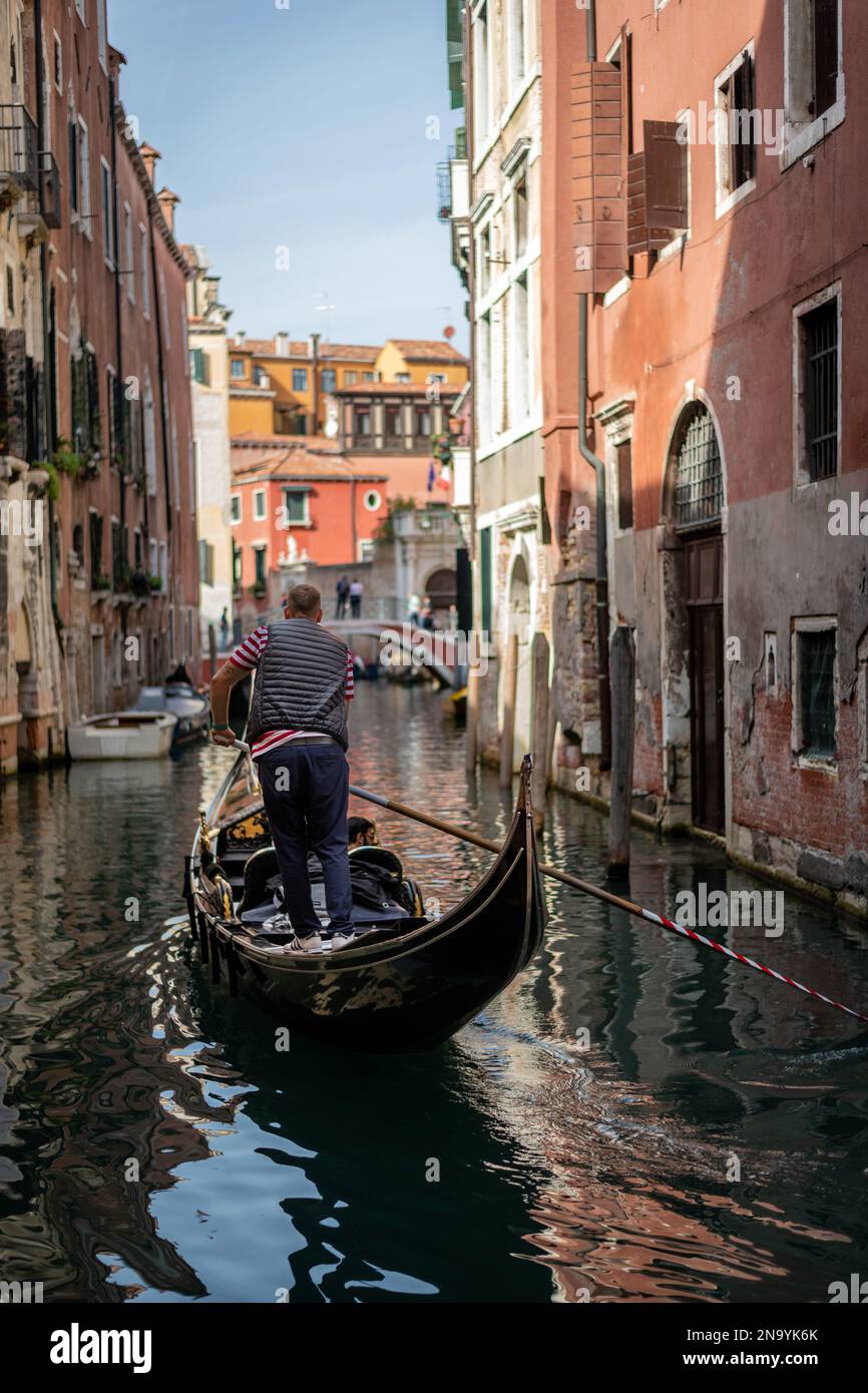 Gondolier steering a gondola, a traditional Venetian row boat on a ...