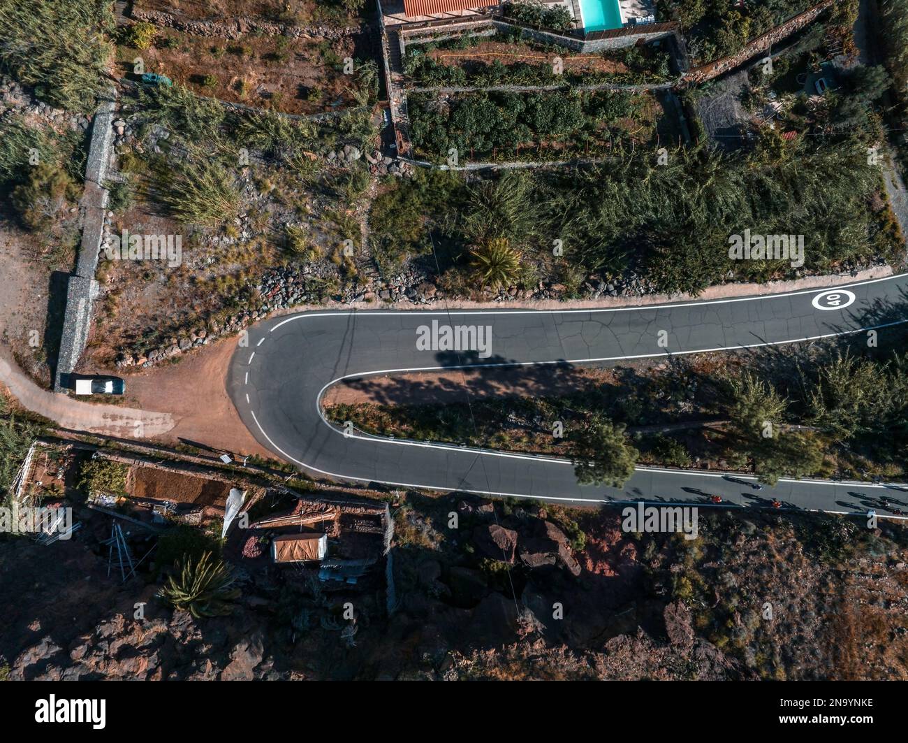 Aerial view of curvy mountain road. Cyclists riding along, getting good ...