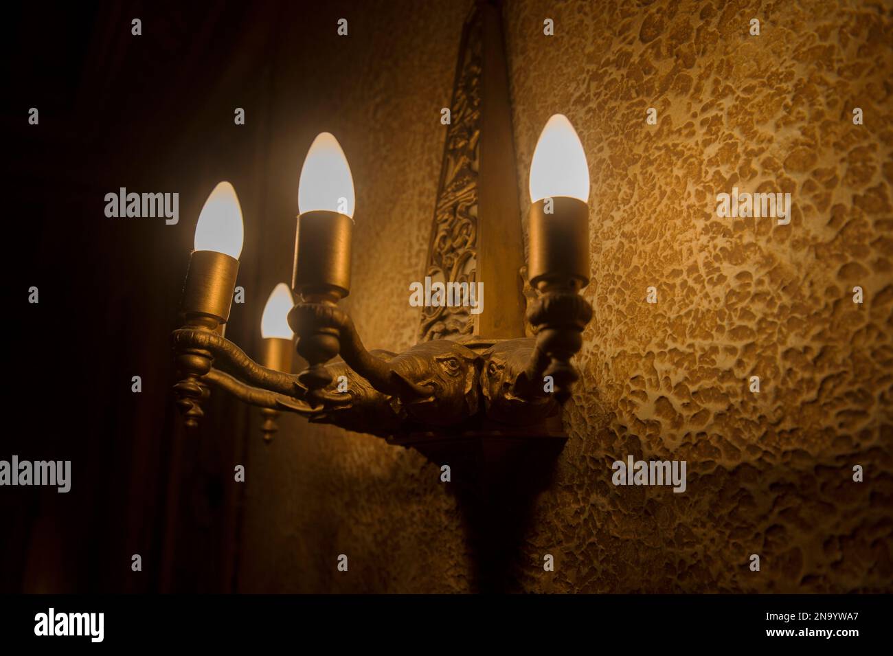 Close-up of a light fixture illuminated on a textured wall in the ...