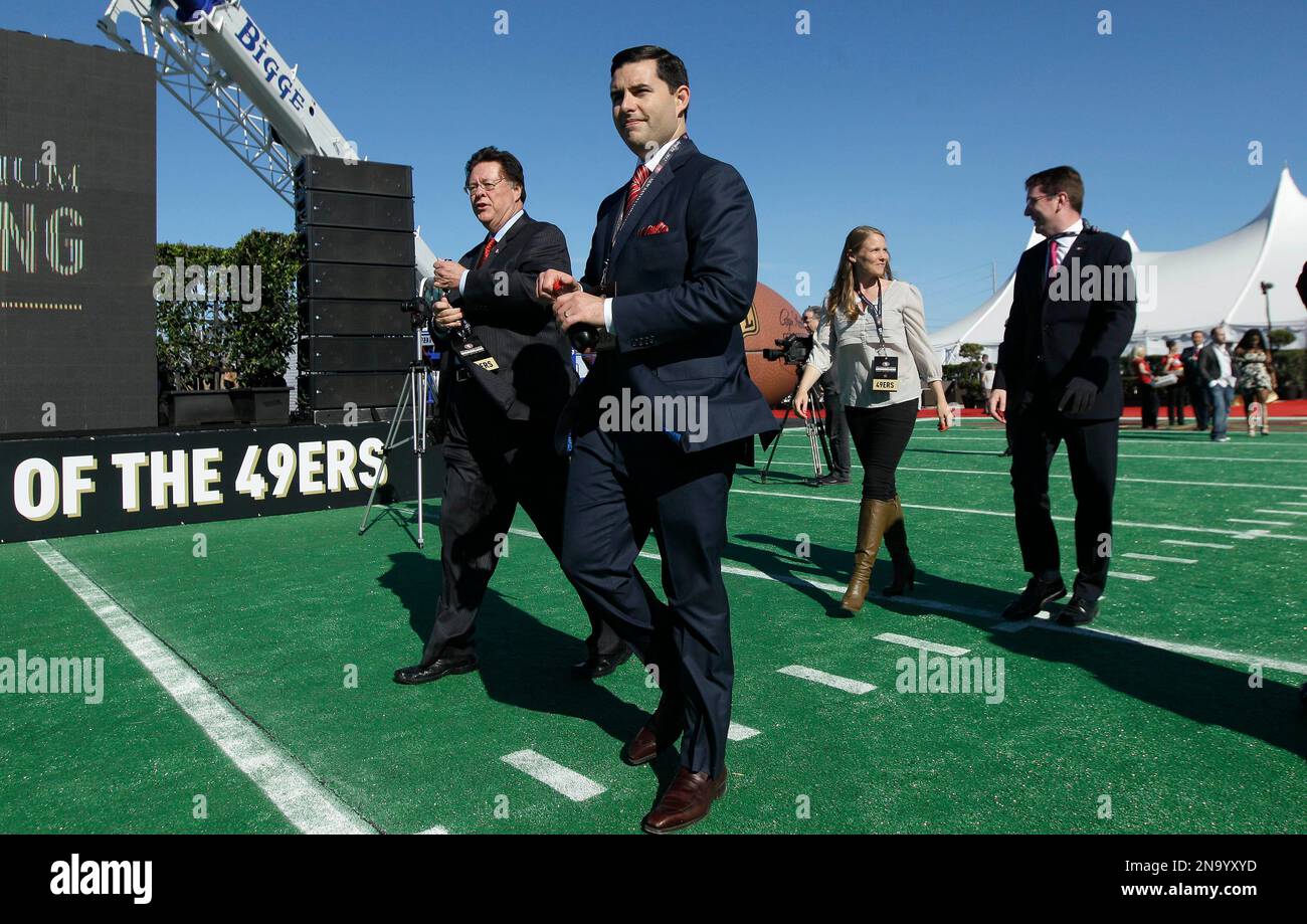 San Francisco 49ers owner Jed York, center, walks his father John York ...