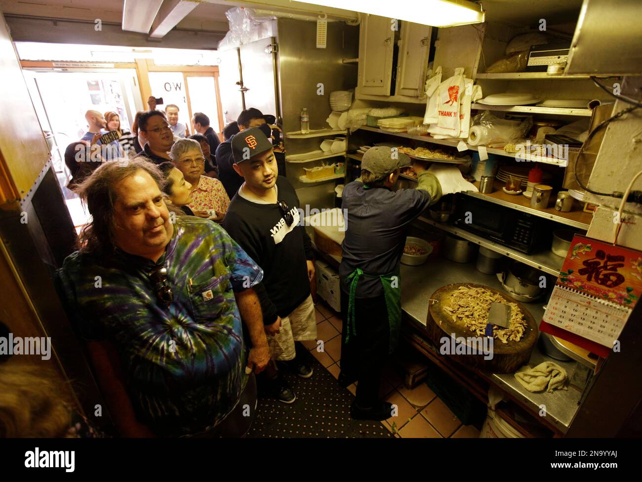 Sam Begler, left, and other customers wait in the kitchen for a table ...