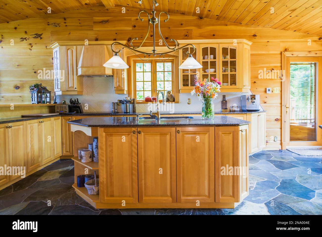 Maple wood island with polished granite countertop and cupboards in ...