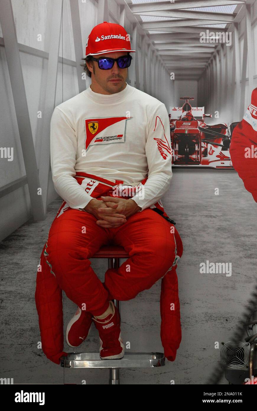 Ferrari driver Fernando Alonso of Spain looks on at pits during the ...
