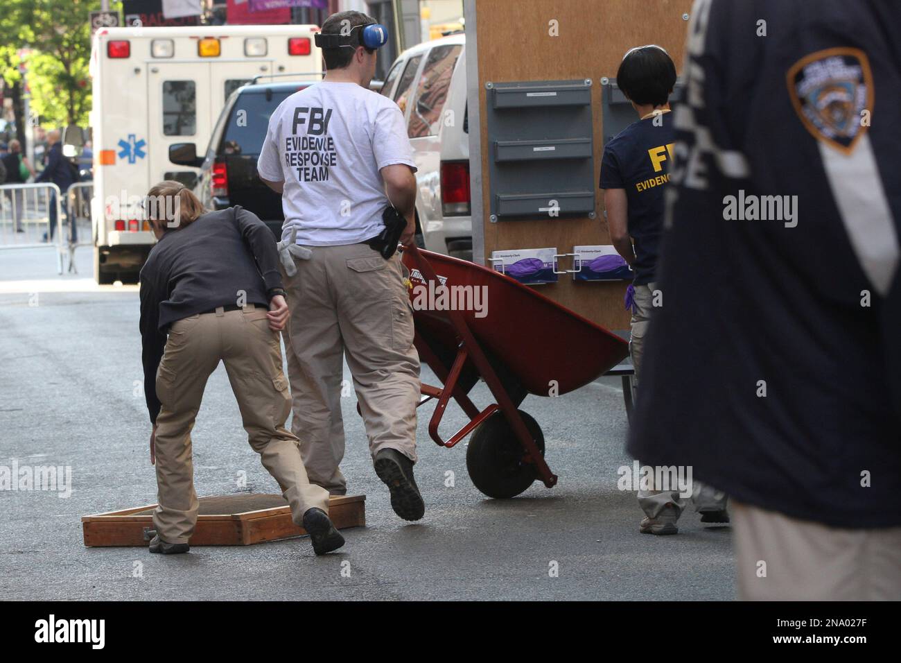 Federal Bureau of Investigation agents move a wheel barrow and a ...