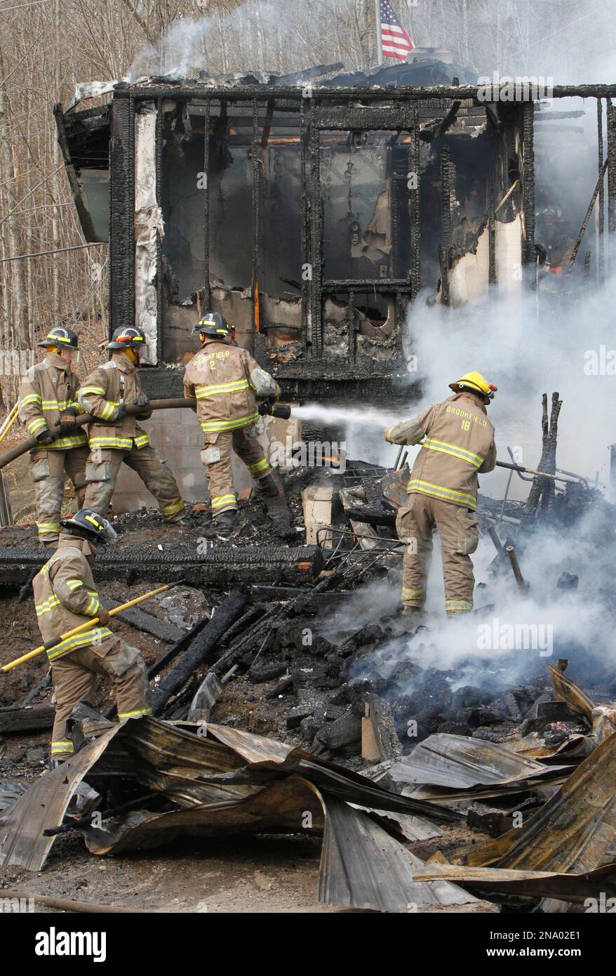 Firefighters extinguish the remains of a house fire on Thursday, April ...