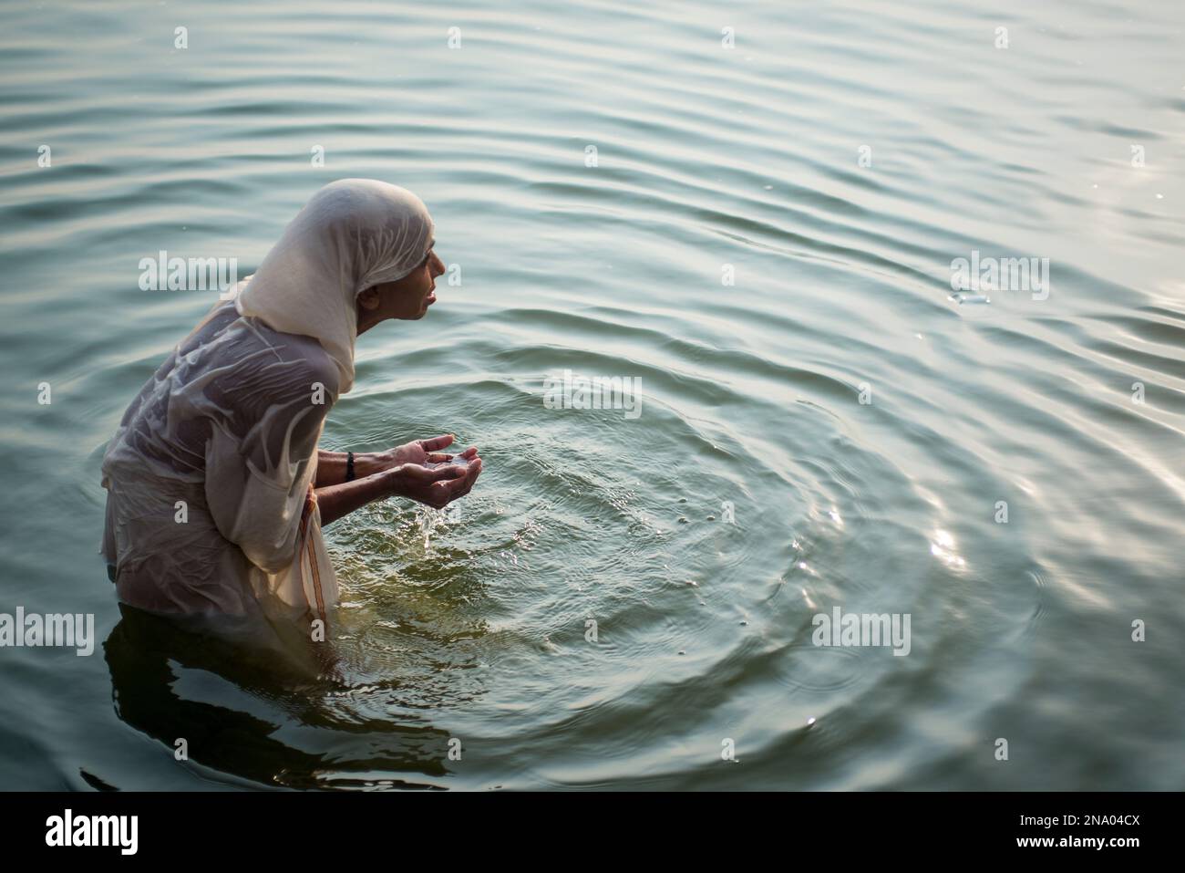 Pilgrim performing puja in the Ganges Stock Photo - Alamy