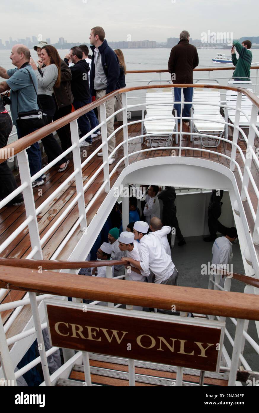 Crew members on lower decks and passengers watch as the MS Balmoral ...