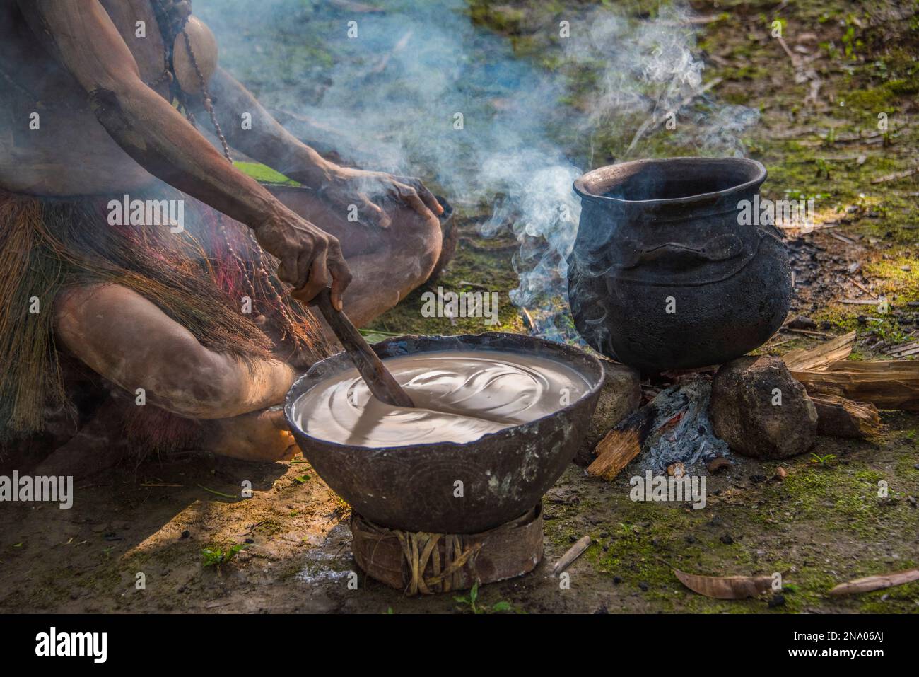 Stirring a food made with sago in Karawari, located in the Sepik area ...