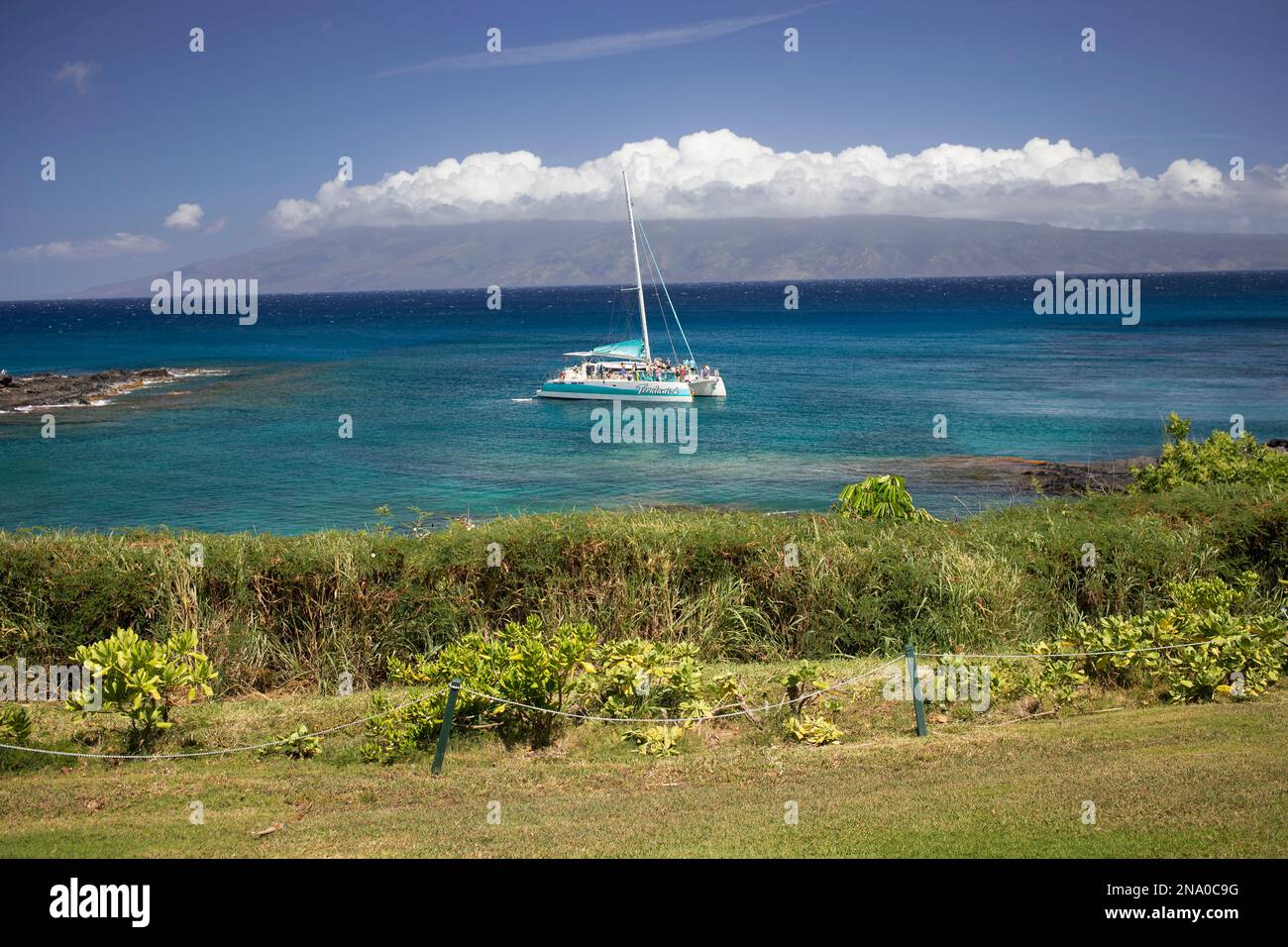 Tourists enjoy a catamaran tour off the island of Maui, Hawaii, USA ...