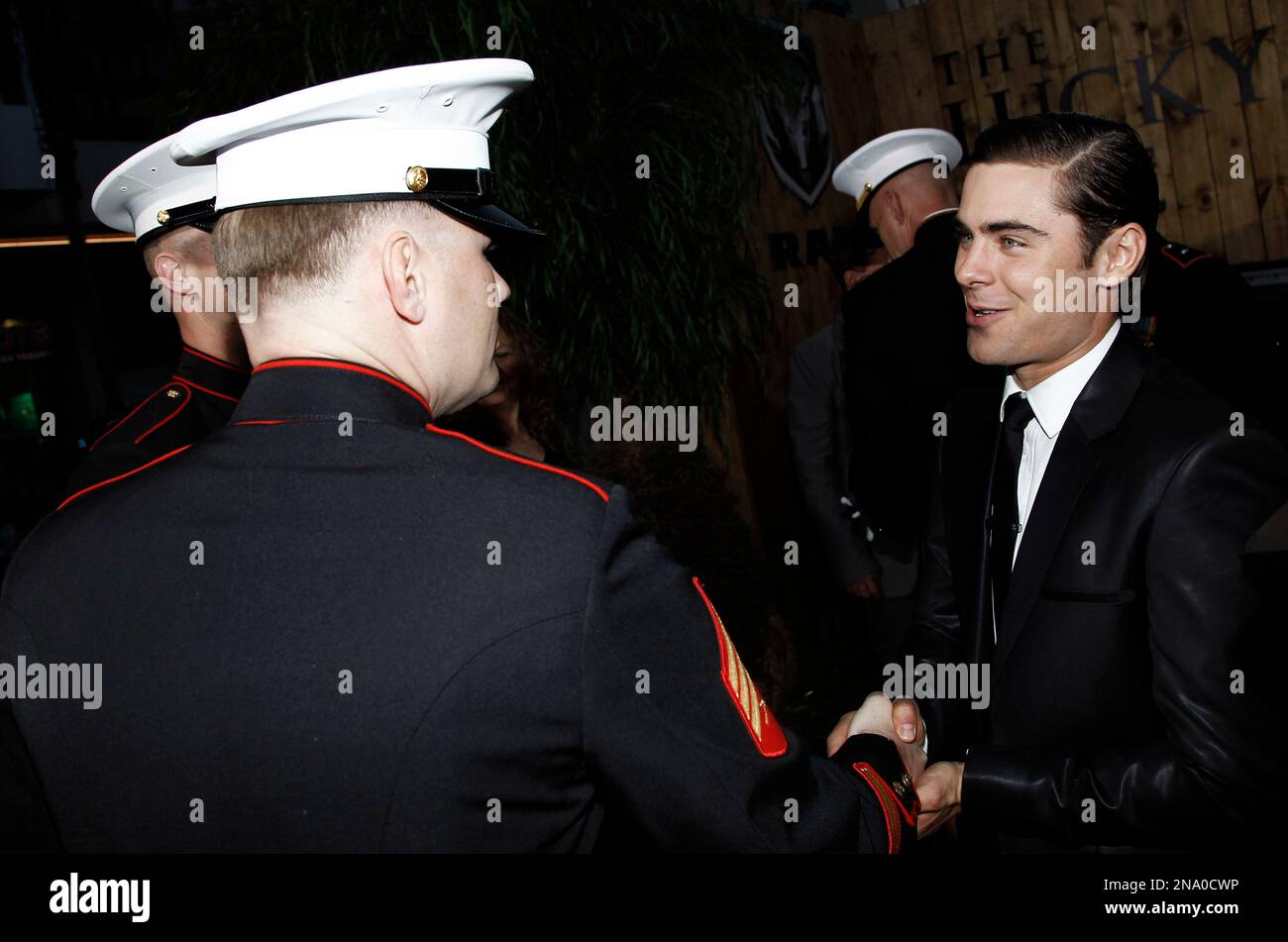 Cast member Zac Efron, center, greets members of the United States ...