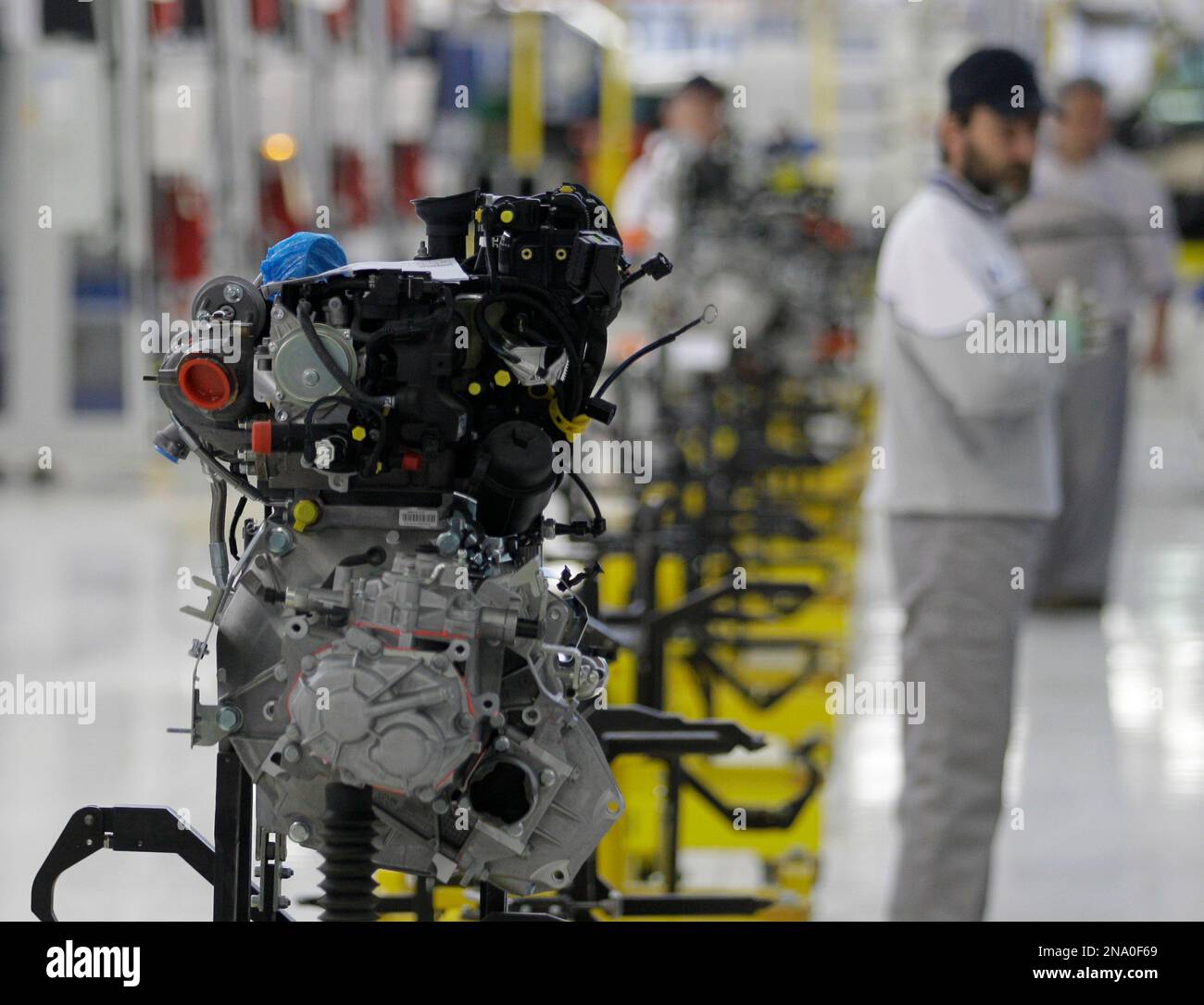 A Serbian factory worker looks at an engine of a Fiat 500 L car in the ...