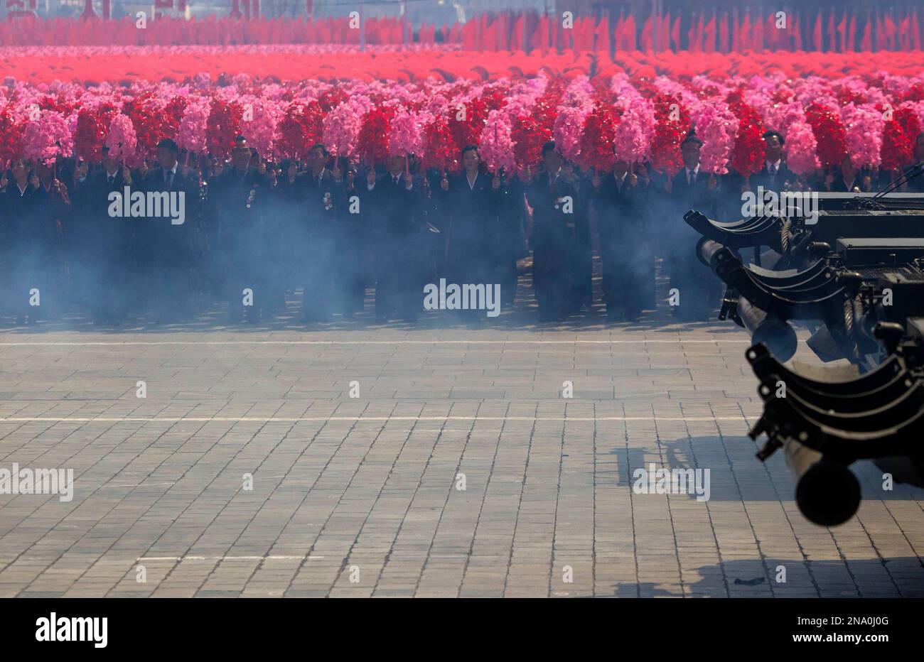 A North Korean military vehicle expels exhaust as it passes by flower ...