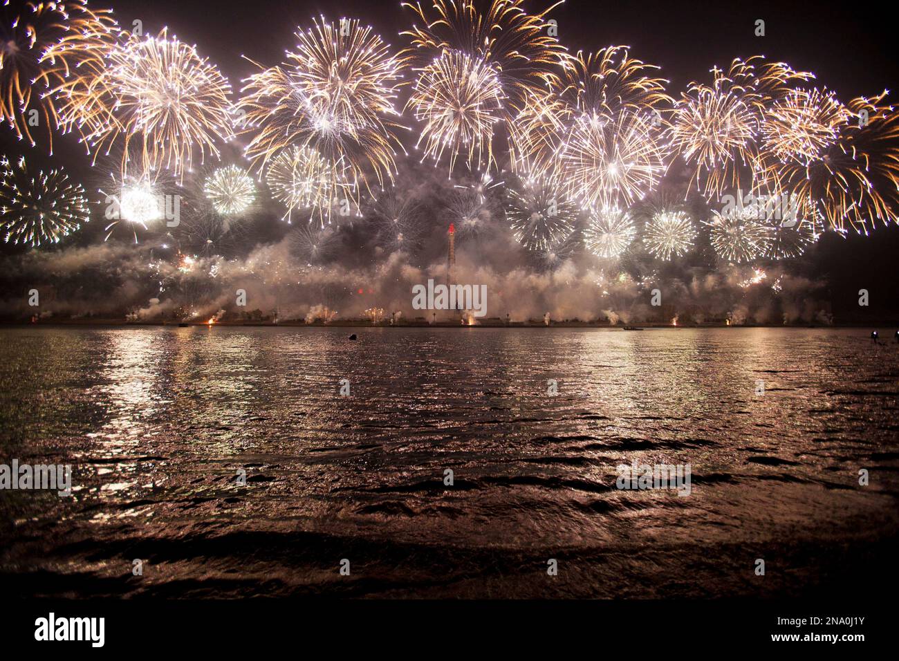 Fireworks are reflected in the Taedong River in Pyongyang as they ...