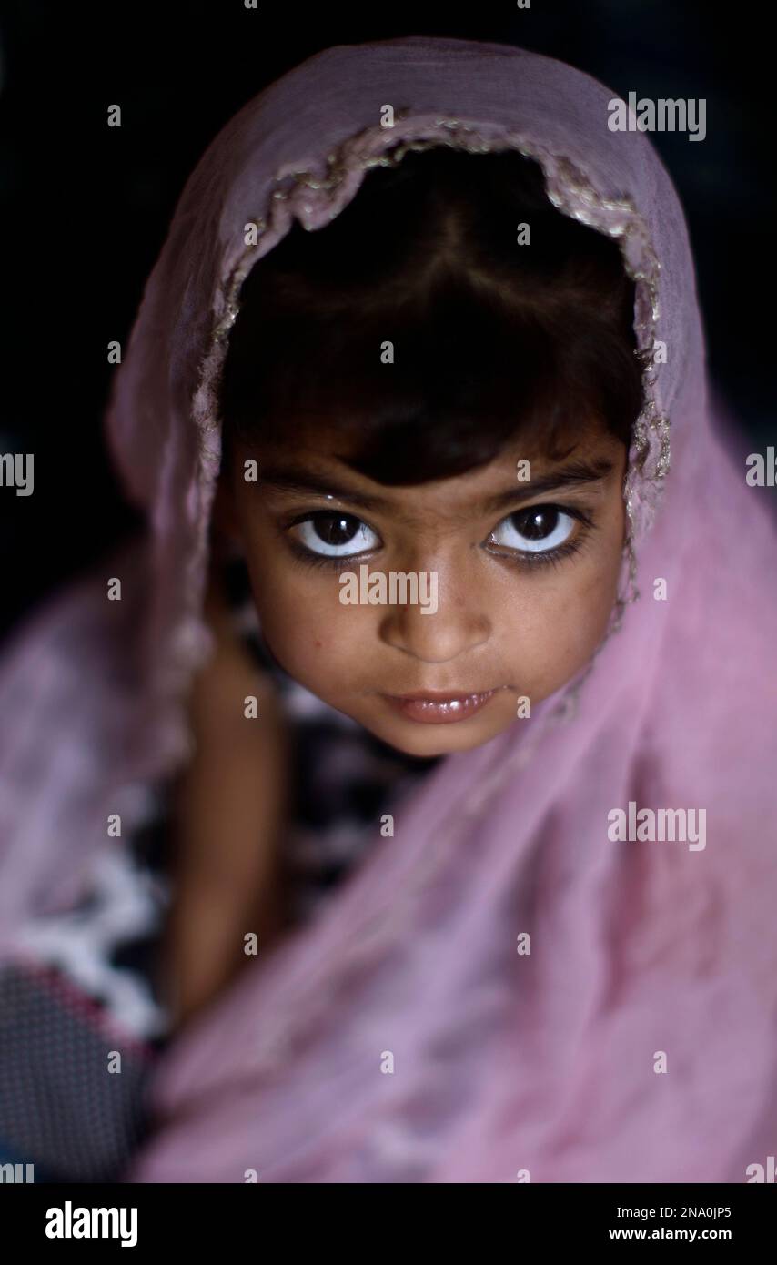 A Pakistani Christian Orthodox girl looks up while attending with her ...