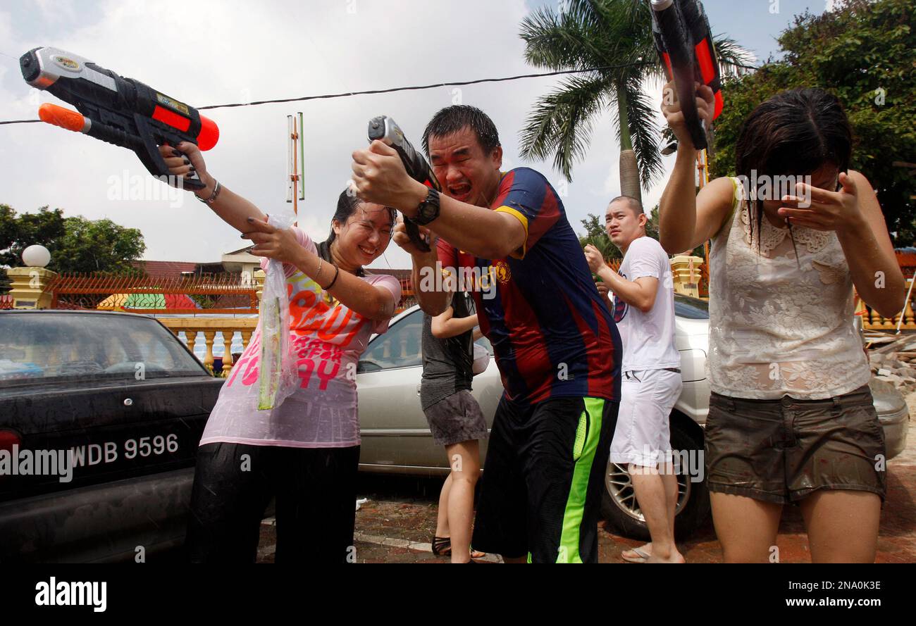 People shoot water guns at each other while celebrating the Songkran ...