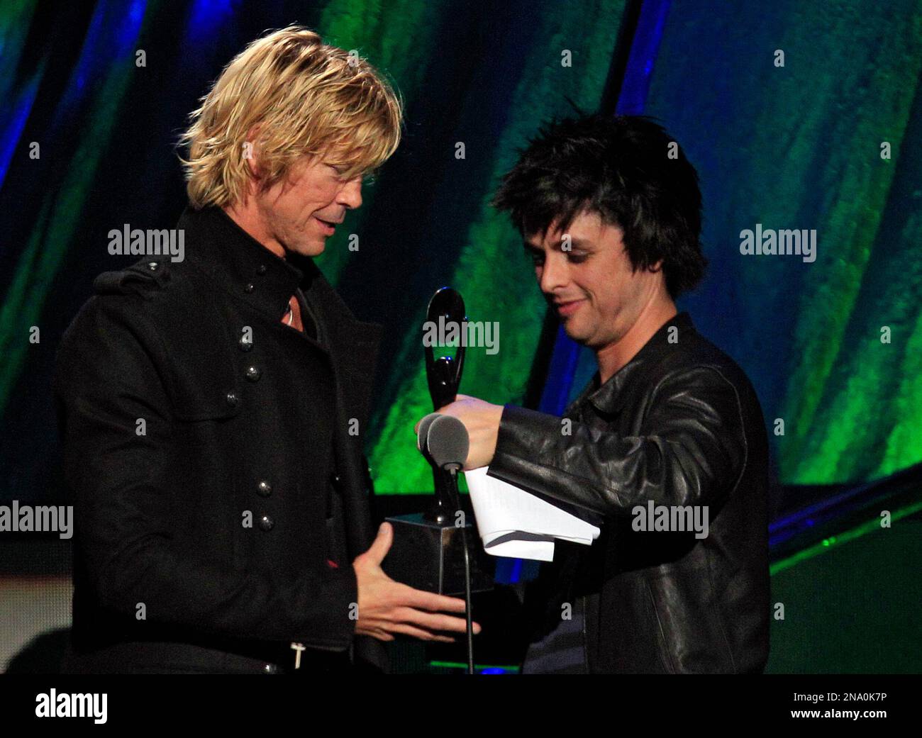 Guns N' Roses' Duff McKagan, left, accepts his trophy from Green Day's ...