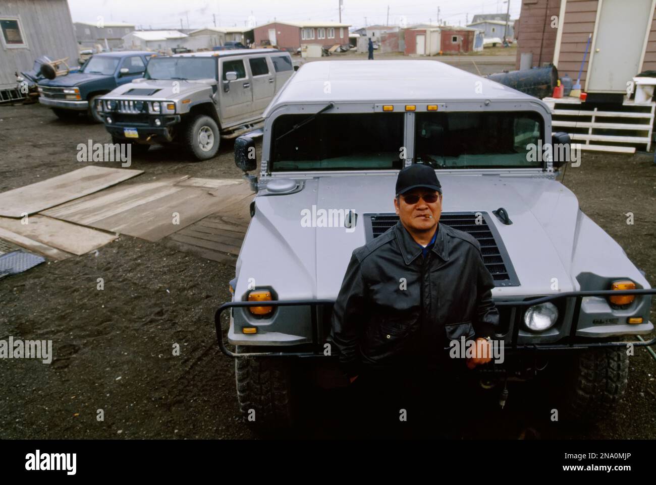 An Inuit man standing in front of his all terrain vehicle; North Slope ...