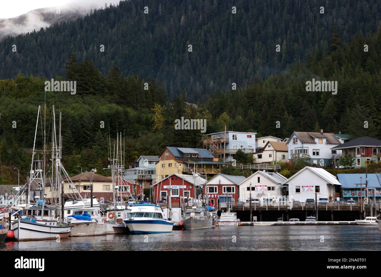 Houses line Ketchikan harbor and fishing boats in marina, Alaska, USA ...