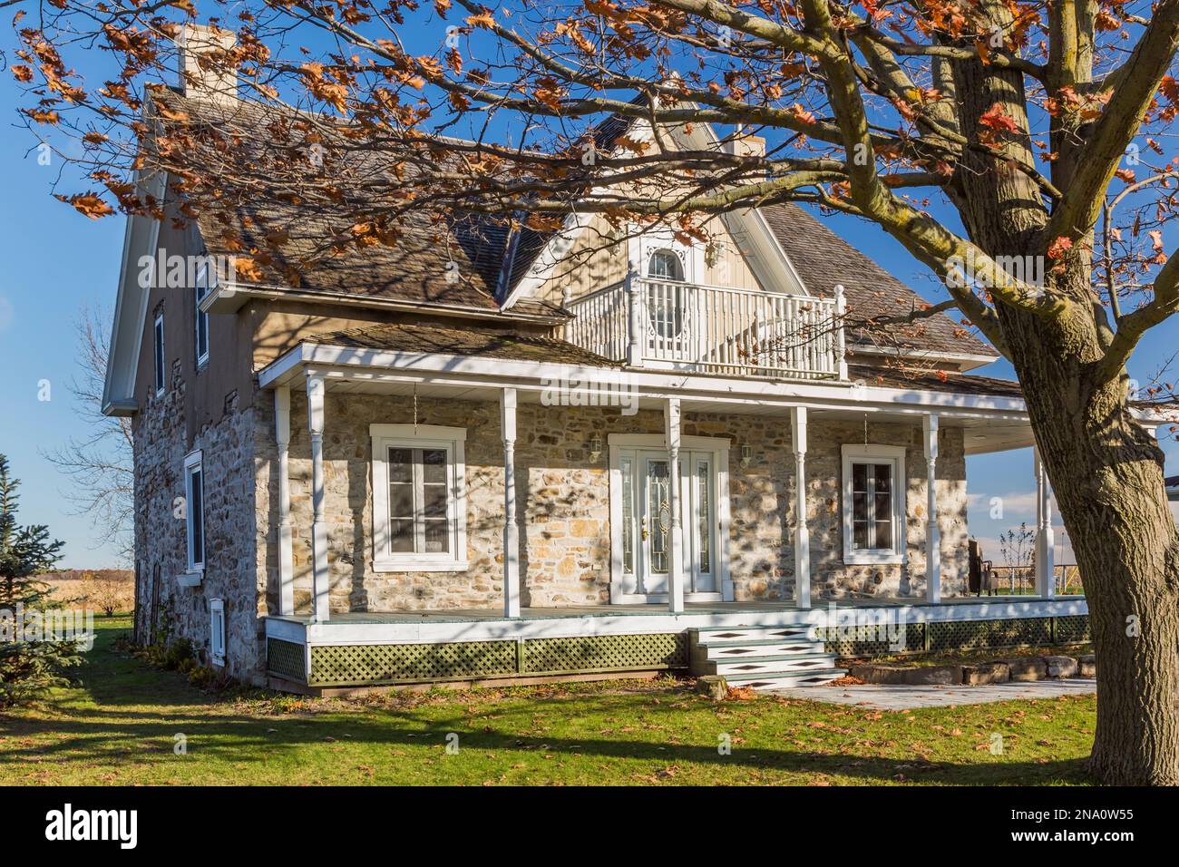 Old 1820 cottage style fieldstone house facade with beige wood plank ...