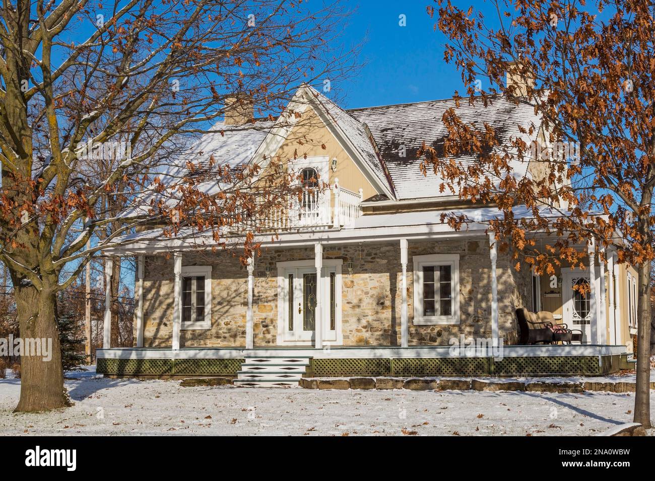 Old 1820 cottage style fieldstone house facade with beige wood plank ...