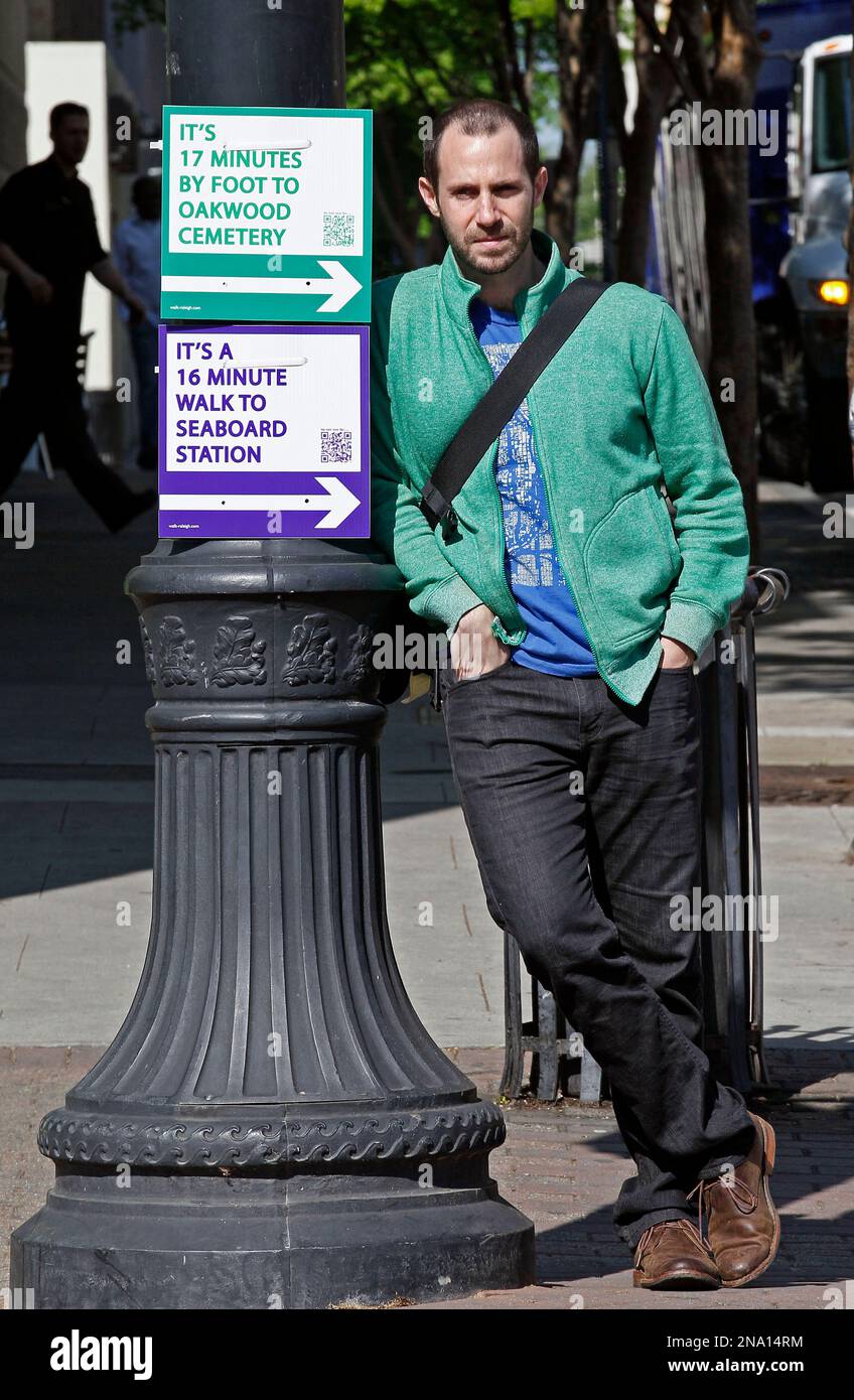 Matt Tomasulo poses for a photo by some of his signs in downtown ...