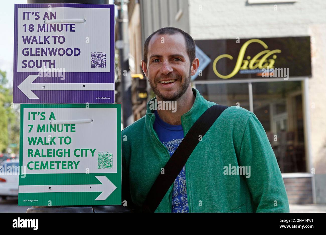 Matt Tomasulo poses for a photo by some of his signs in downtown ...