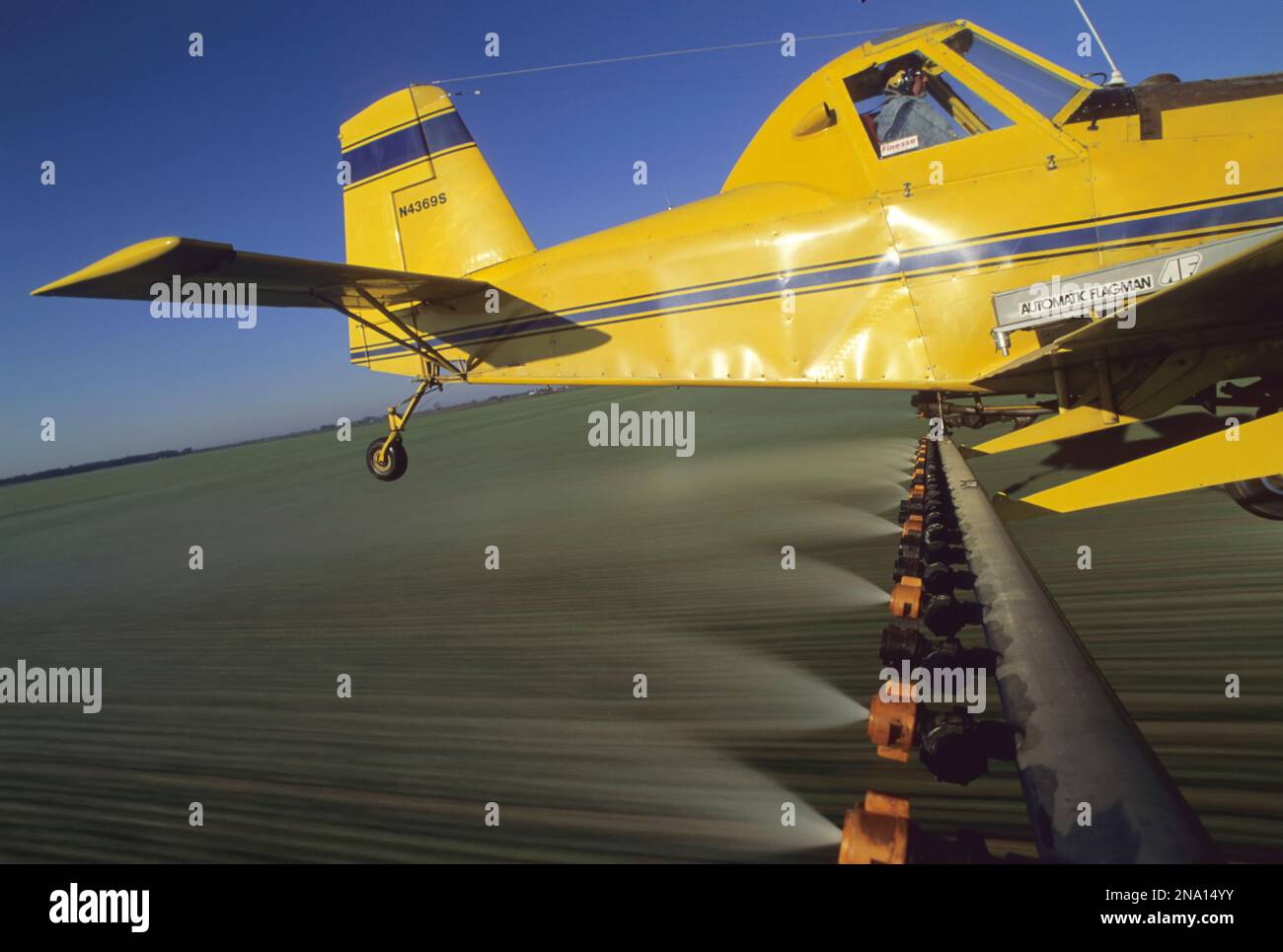 A crop duster sprays a winter wheat field with pesticides; Pond Creek ...