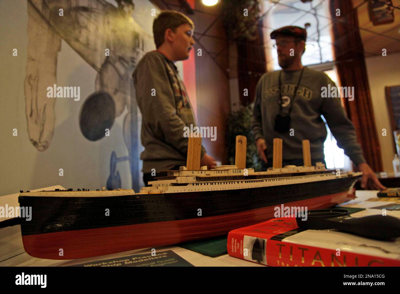 Passengers talk behind a model of the Titanic onboard the MS Balmoral ...