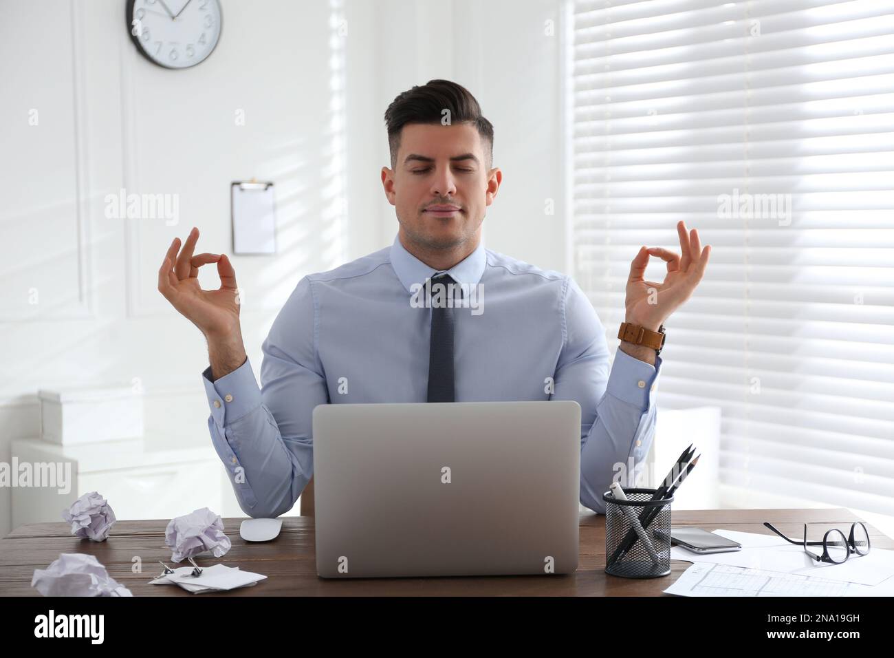 Businessman meditating at workplace in office. Stress relieving ...