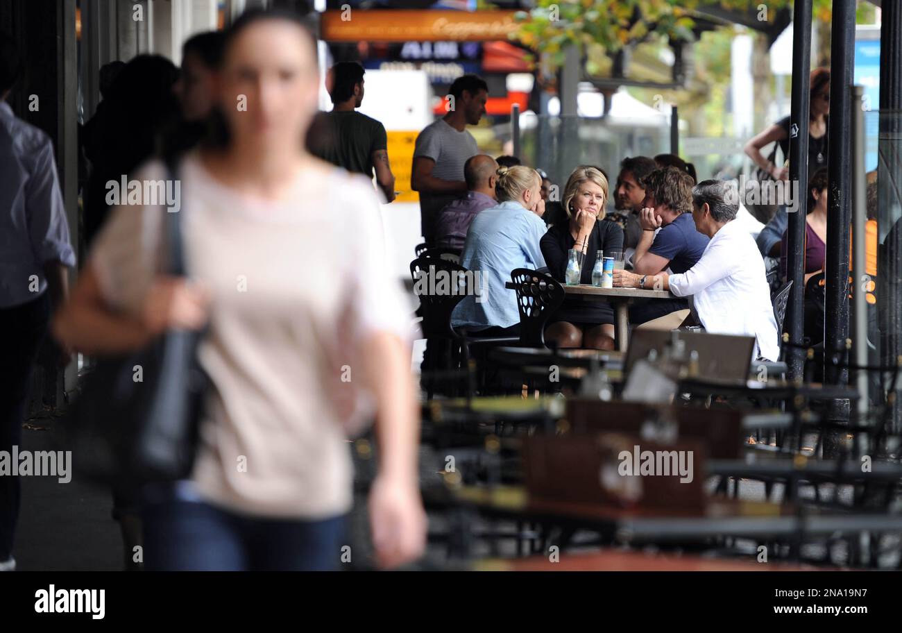 People sitting on the footpath outside cafe's in Lygon Street ...