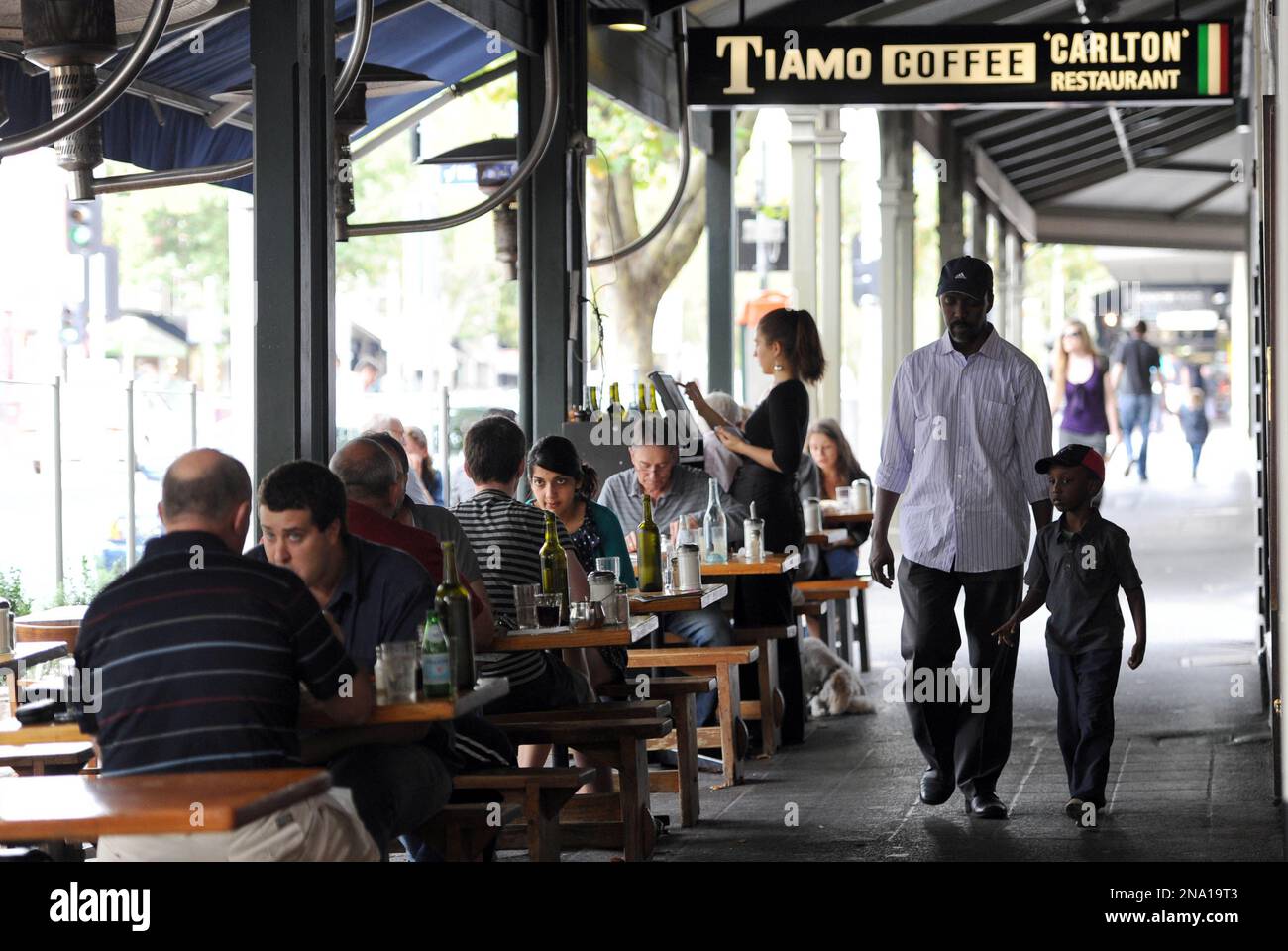 People sitting on the footpath outside cafe's in Lygon Street ...