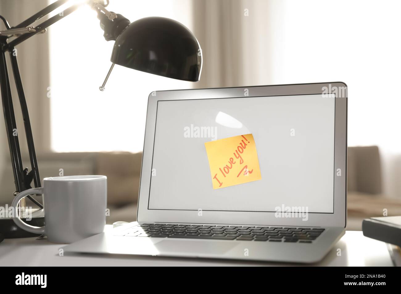 Sticky note with handwritten text I Love You attached to laptop screen ...