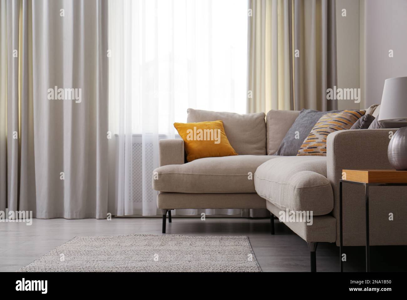 Modern comfortable sofa near window in stylish living room. Interior ...