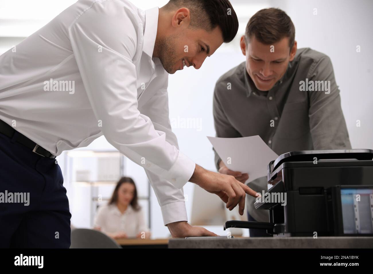Employees using new modern printer in office Stock Photo - Alamy
