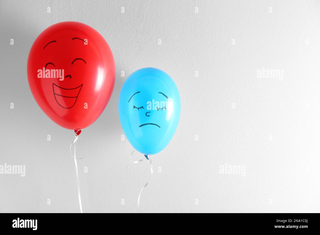 Air balloons with drawn sad and happy faces on white background. Space ...