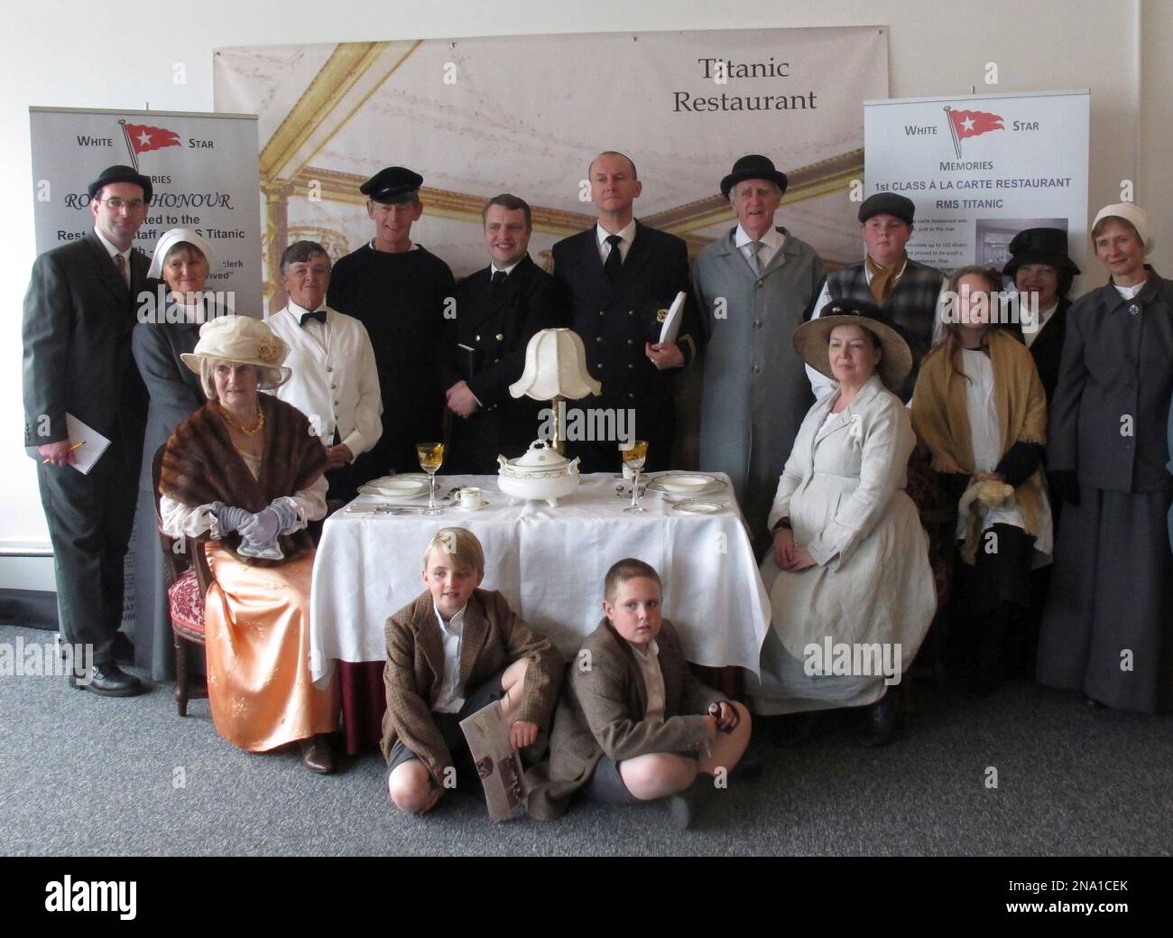 People wearing costumes pose for pictures around a mock up of a first ...