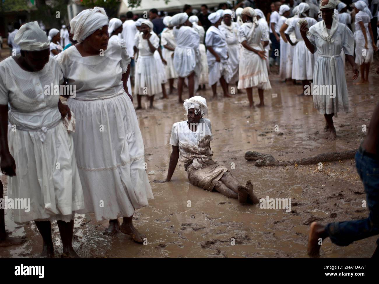 A Voodoo believer sits on the mud during a Voodoo ceremony in ...