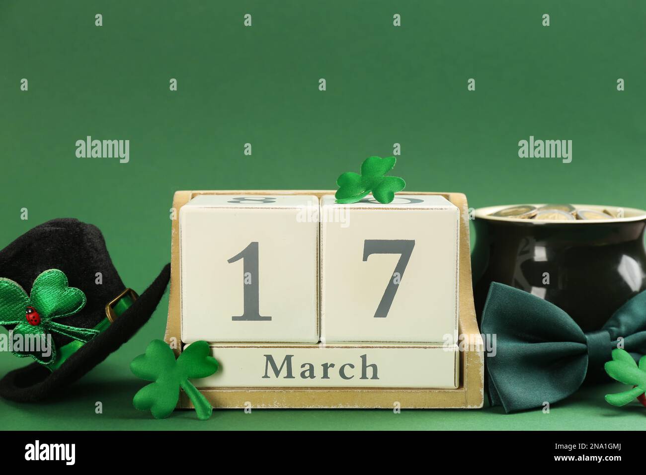 Leprechaun's hat, block calendar and St. Patrick's day decor on green ...