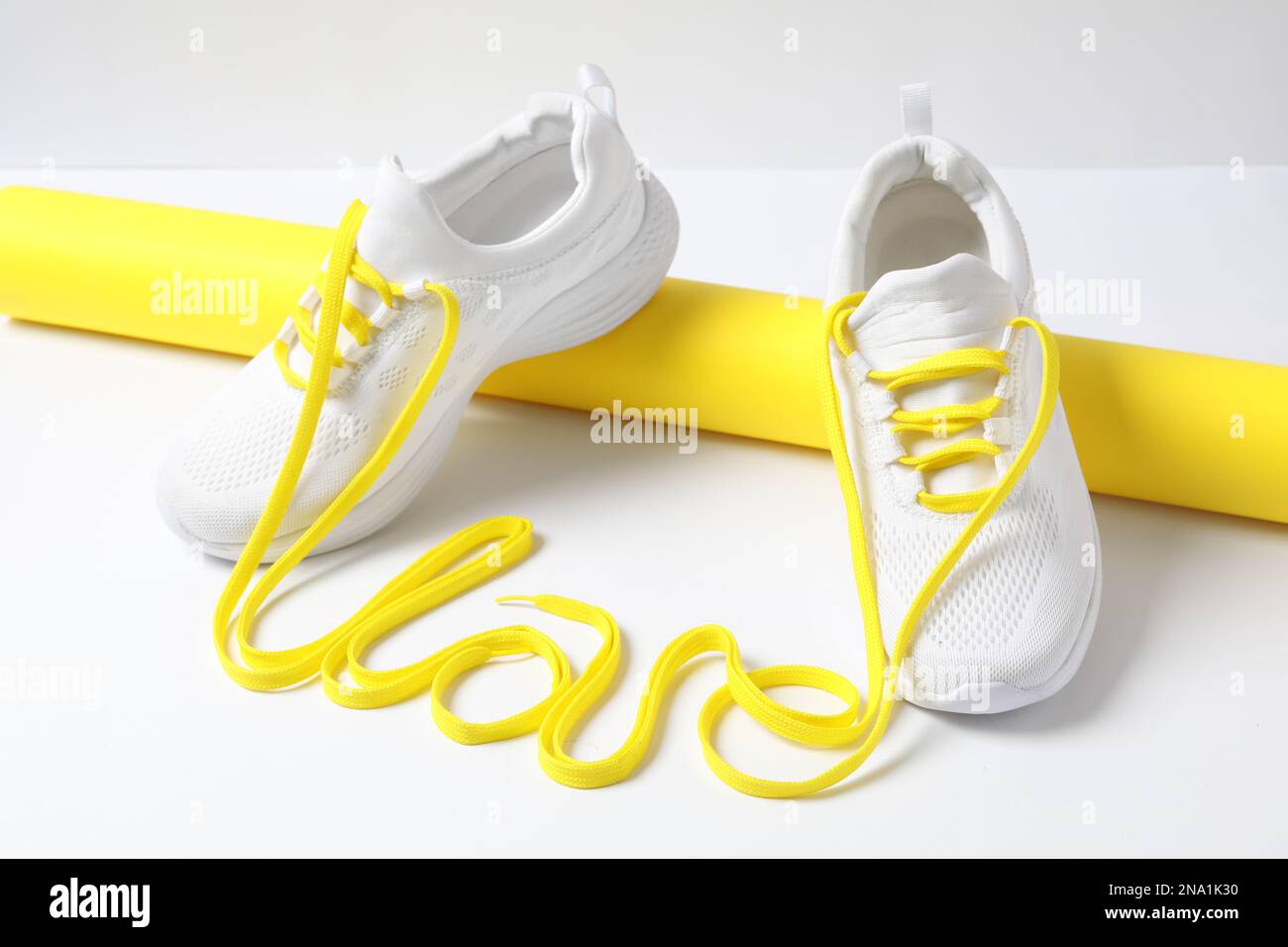 Stylish sneakers and word Love made with yellow shoe laces on white ...