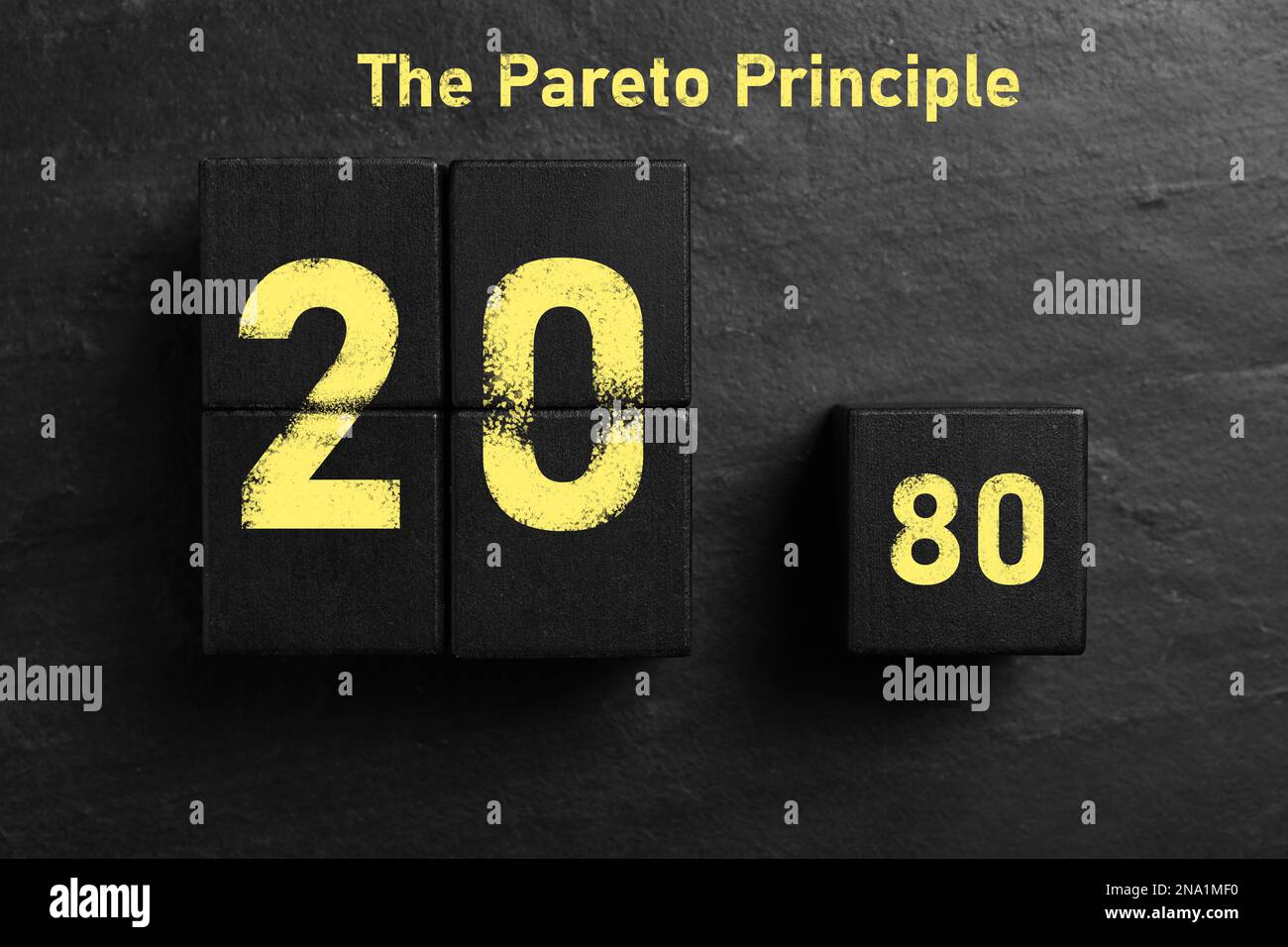 Flat lay composition with cubes on black slate background. Pareto ...
