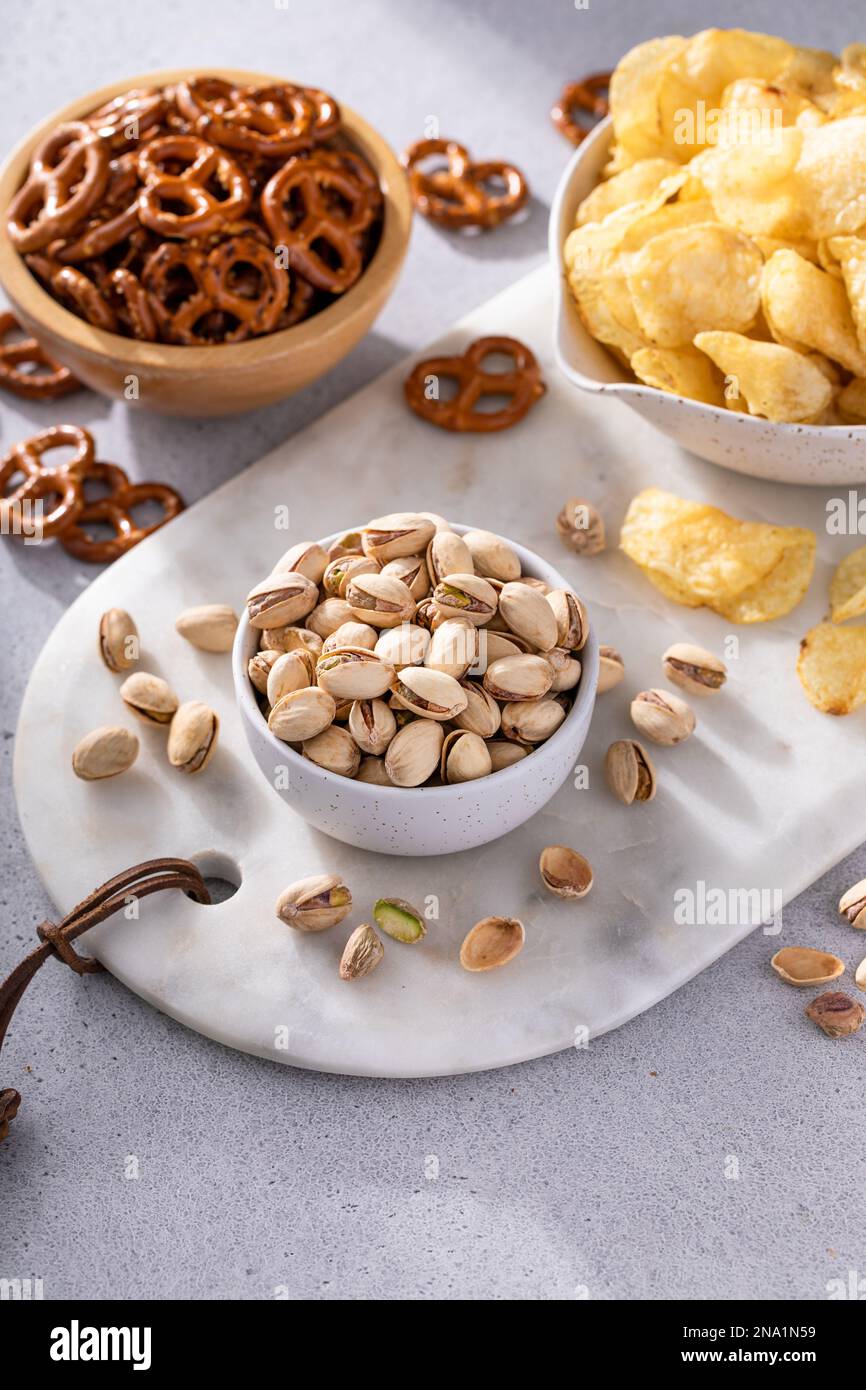 Variety of salty snacks on the table with pretzels, pistachios and ...