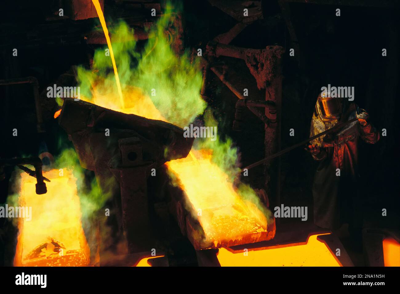 Man in protective gear tends a smelter at Magma Metals Company, near ...
