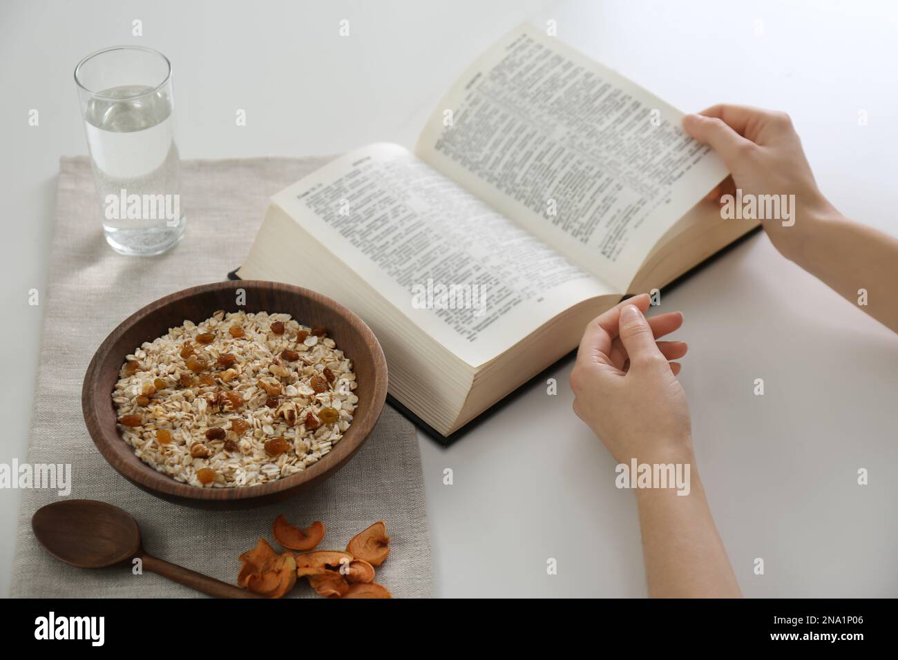 Woman with Bible having dinner at home, closeup. Great Lent season ...