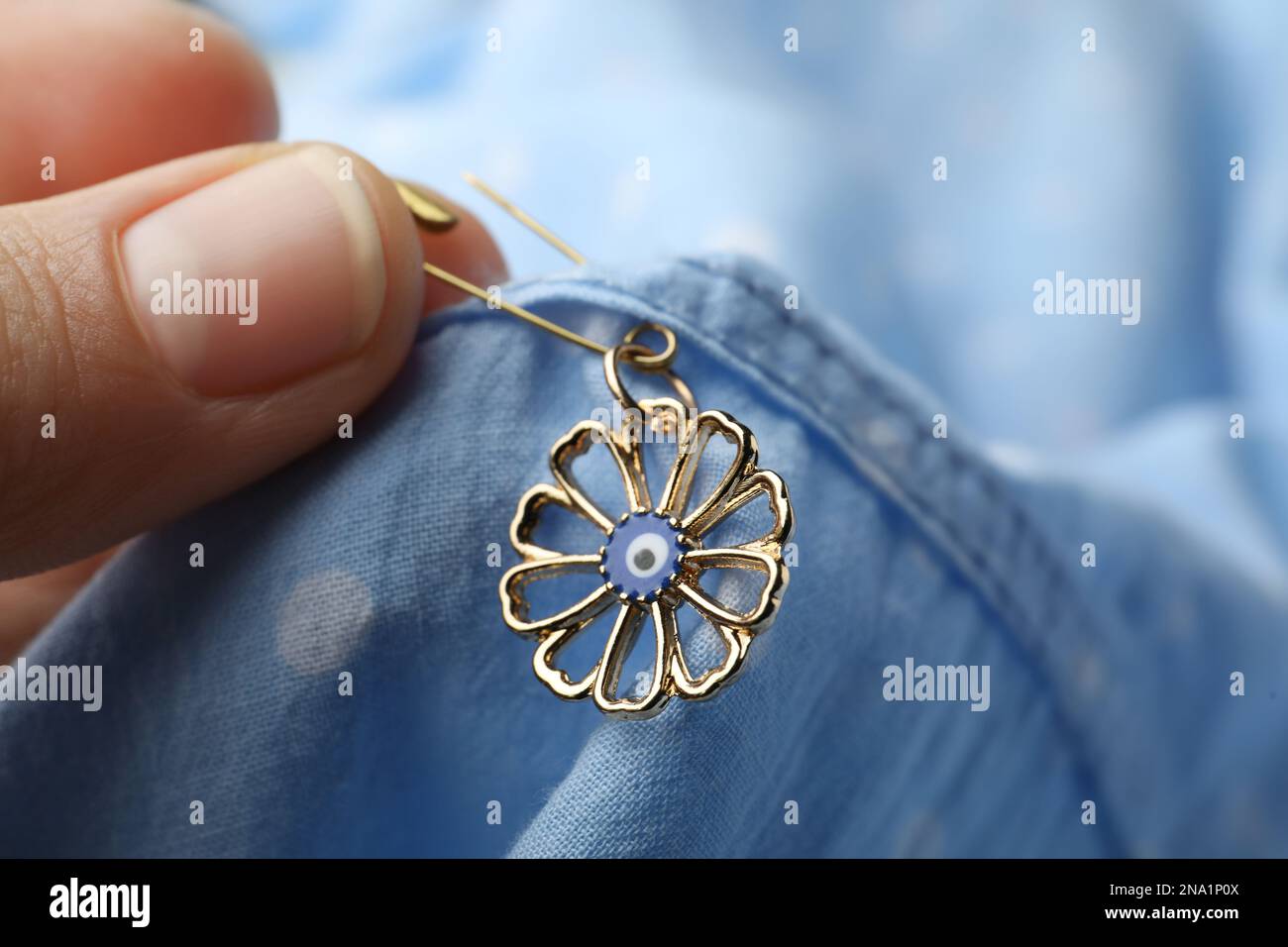 Woman pinning evil eye amulet on clothing, closeup Stock Photo - Alamy