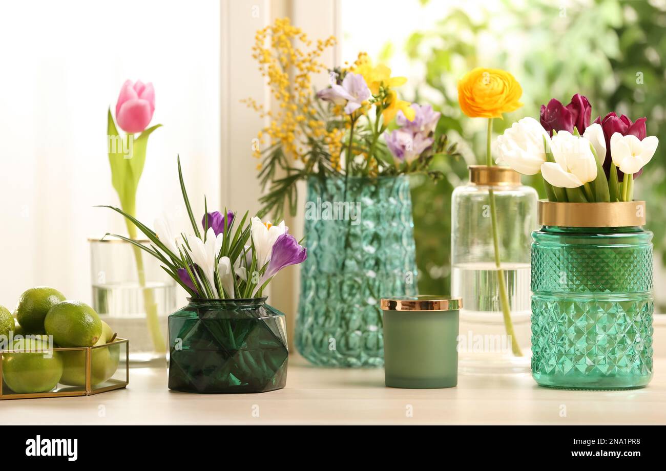 Different beautiful spring flowers and candle on window sill Stock ...