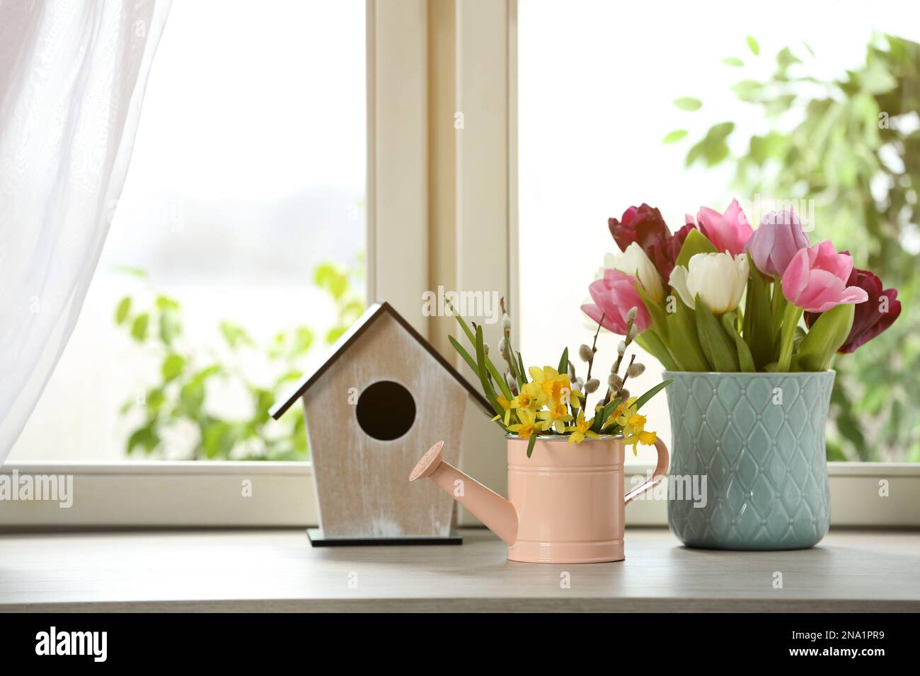 Beautiful spring flowers with birdhouse on window sill Stock Photo - Alamy