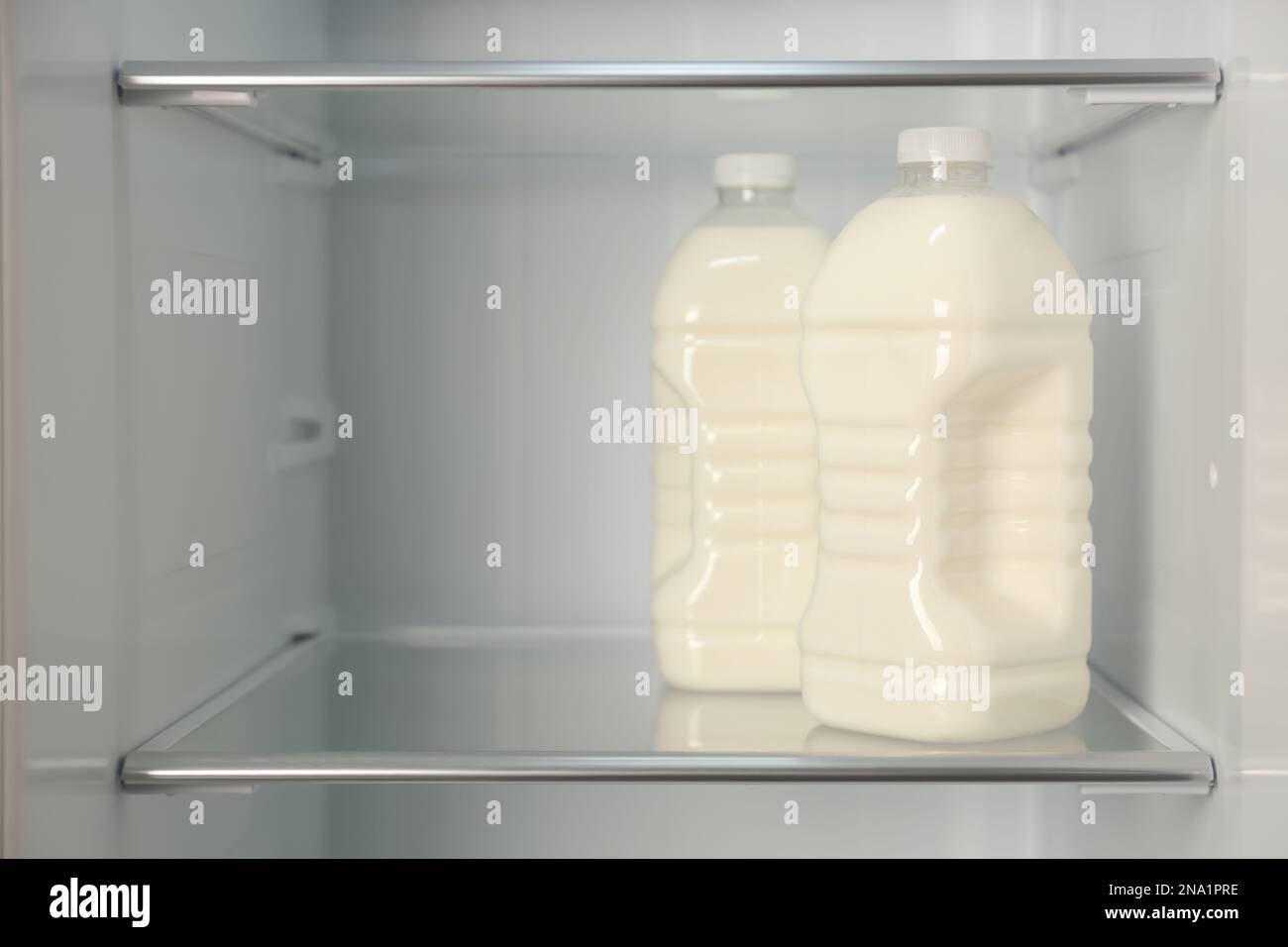 Gallons of fresh milk in refrigerator, closeup. Space for text Stock ...