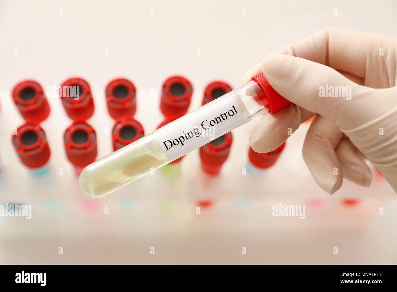 Doctor holding test tube with sample over table, closeup. Doping ...